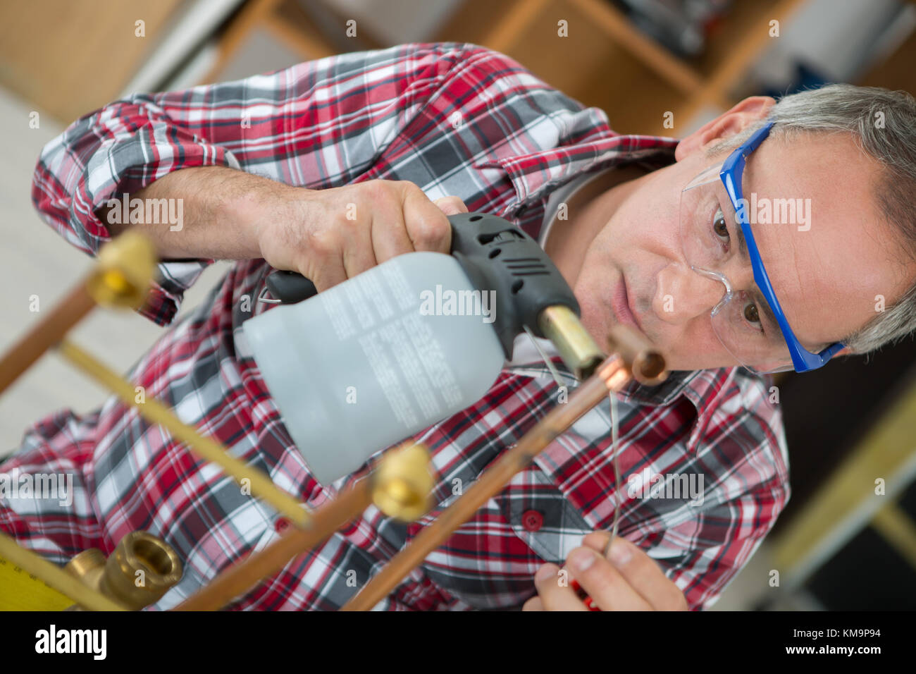 man using a blowtorch with cooper pippes Stock Photo - Alamy