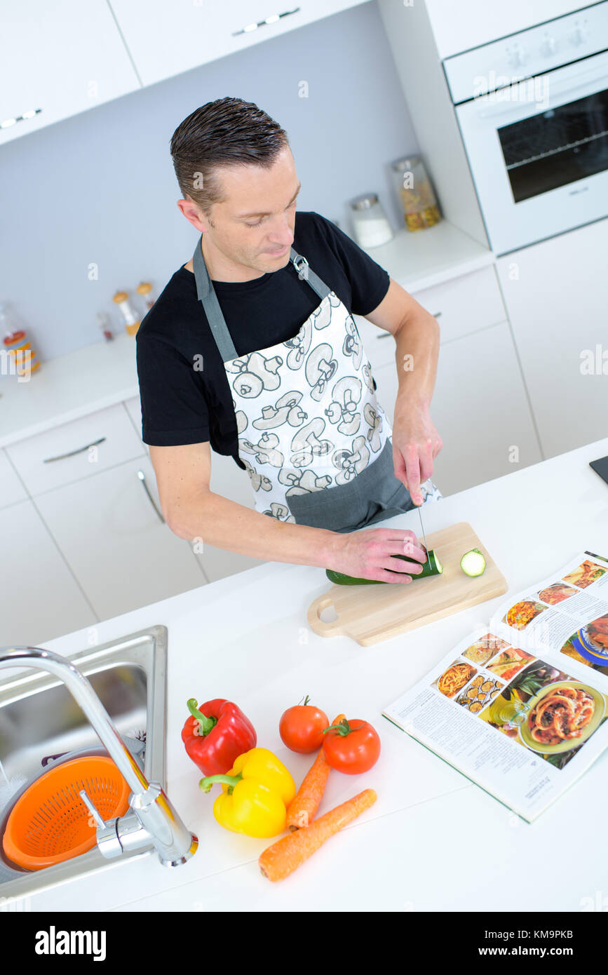 man at home preparing meal chopping courgettes Stock Photo - Alamy