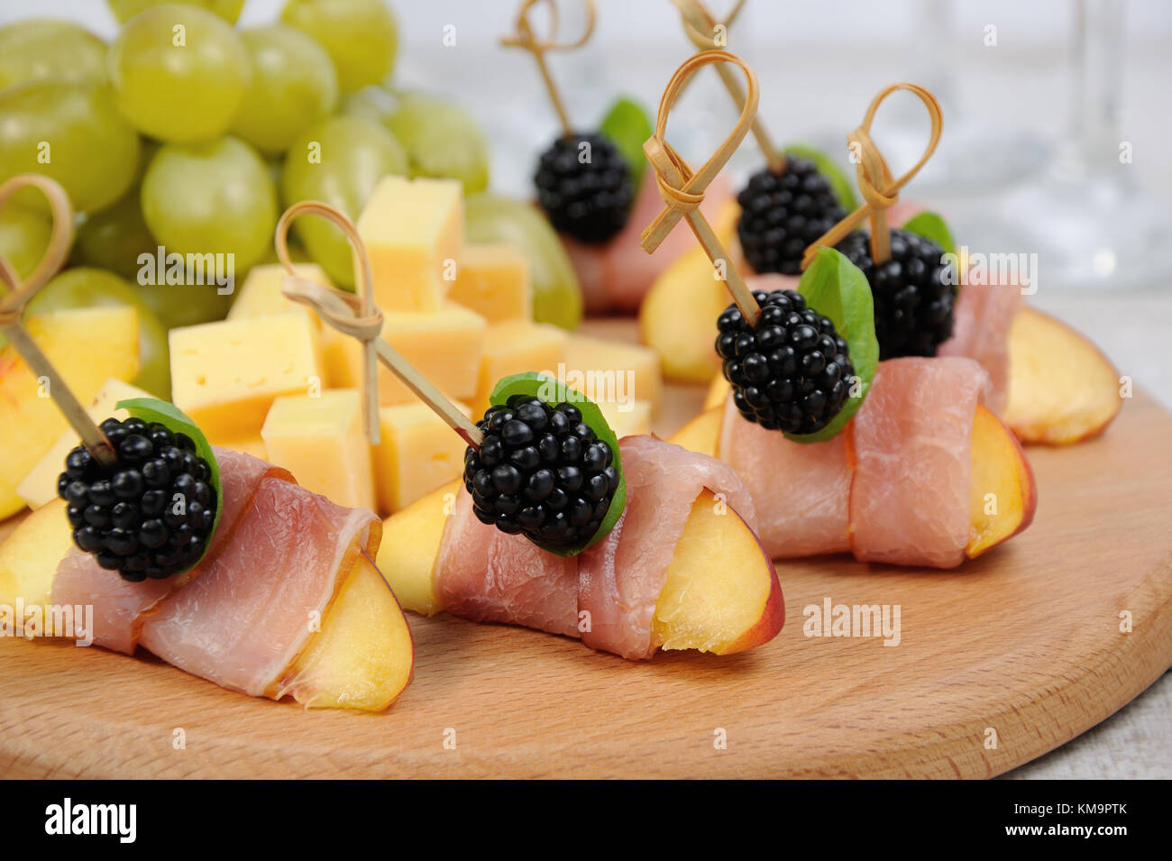 Canape from peach with dried ham and blackberries Stock Photo - Alamy