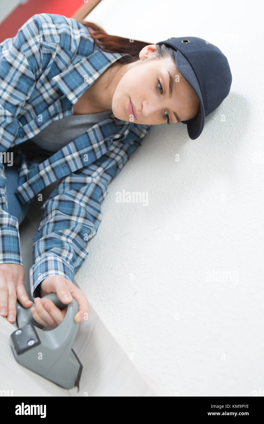 young female craftsman fitting carpet on floor Stock Photo - Alamy