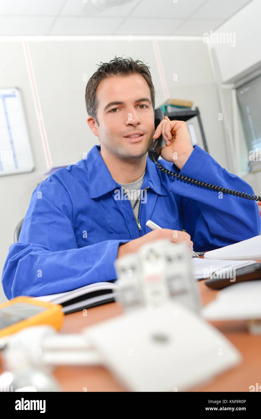 Electrician on the phone to a customer Stock Photo - Alamy