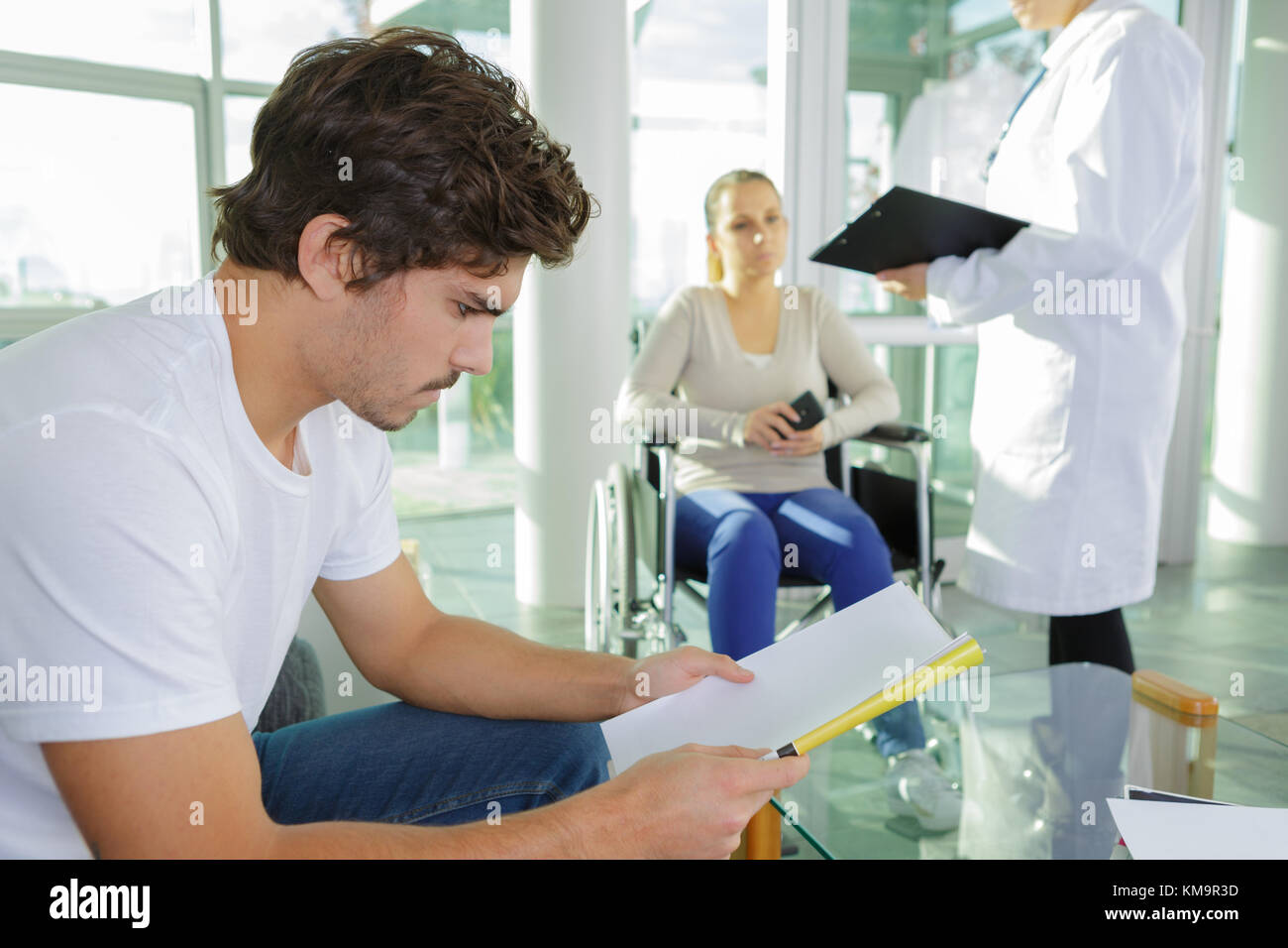 young man reading while waiting for his turn Stock Photo - Alamy