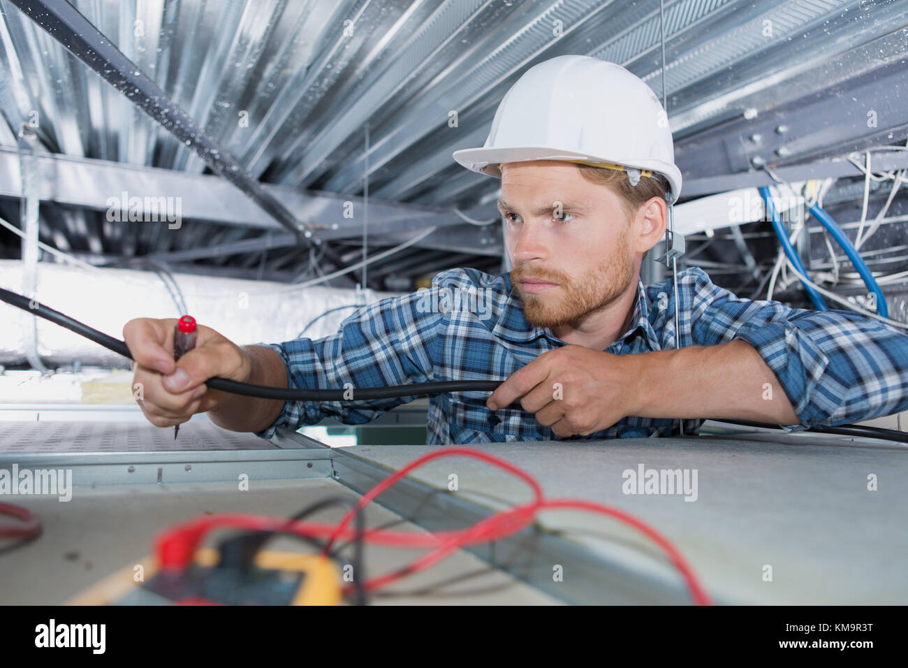 electrician checking wiring in office Stock Photo - Alamy