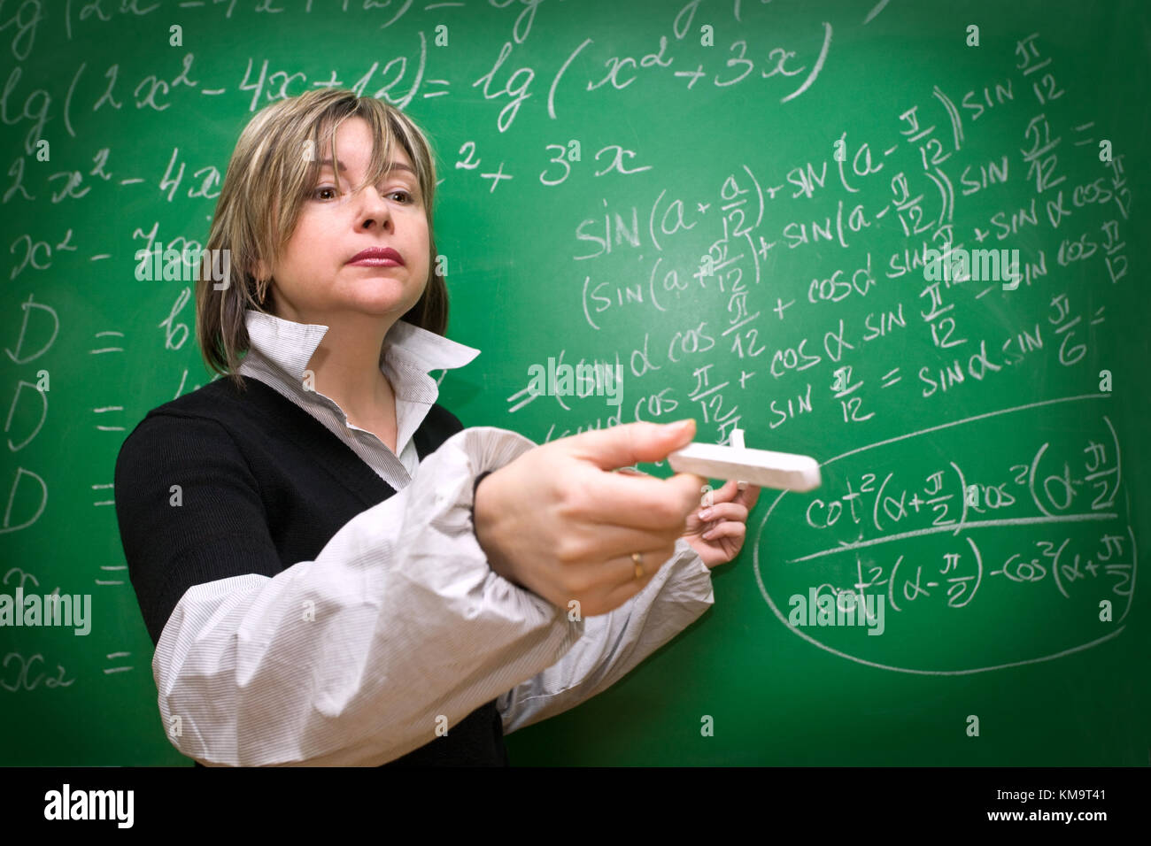 teacher shows the formula on the green chalkboard Stock Photo - Alamy
