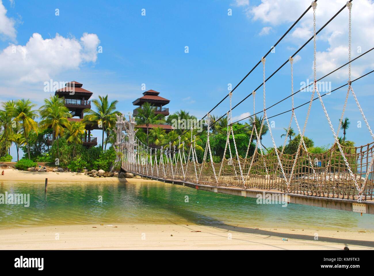 Wooden bridge leading to paradise island across a beautiful lagoon ...