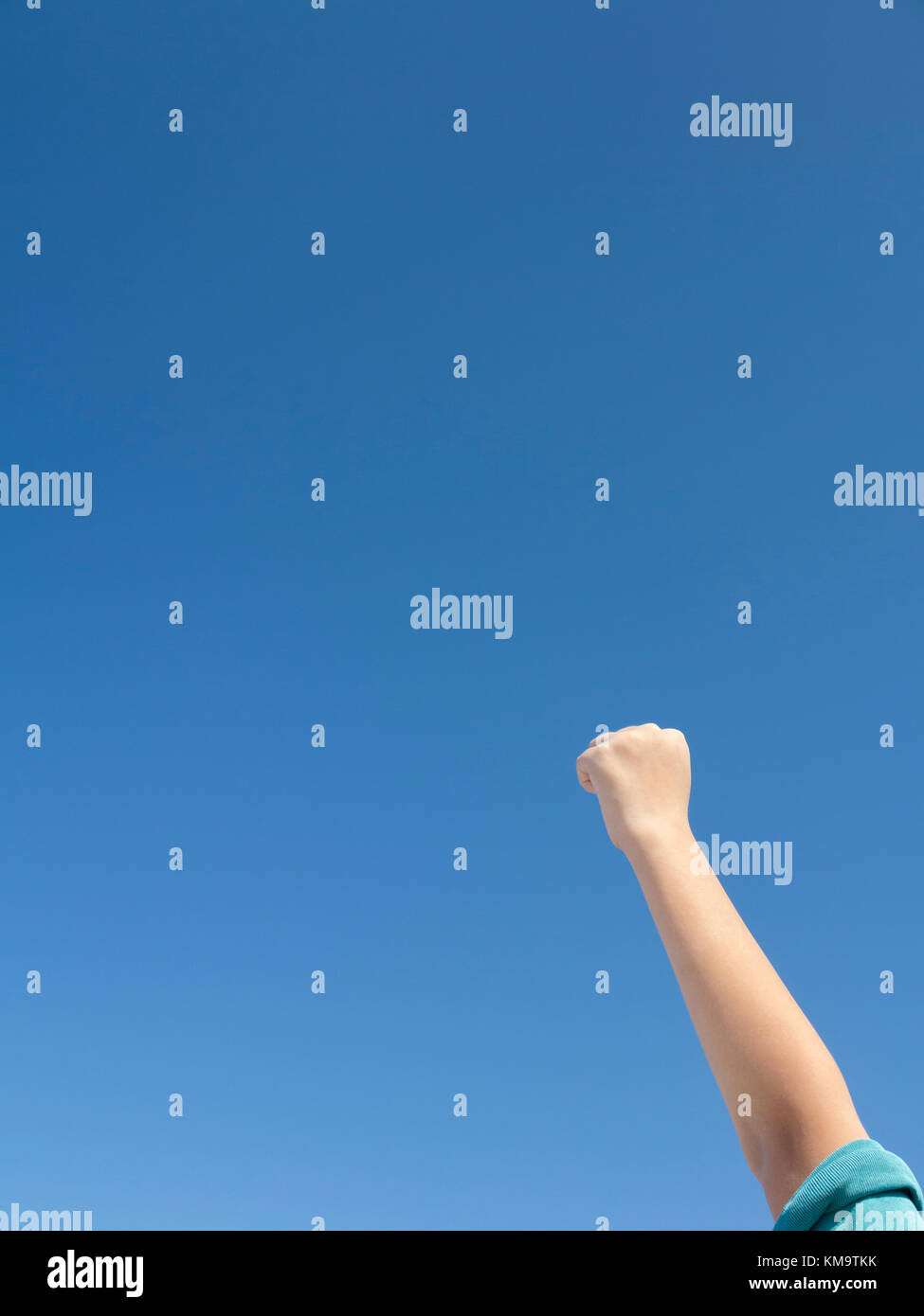 Young girl's fist against blue sky Stock Photo - Alamy