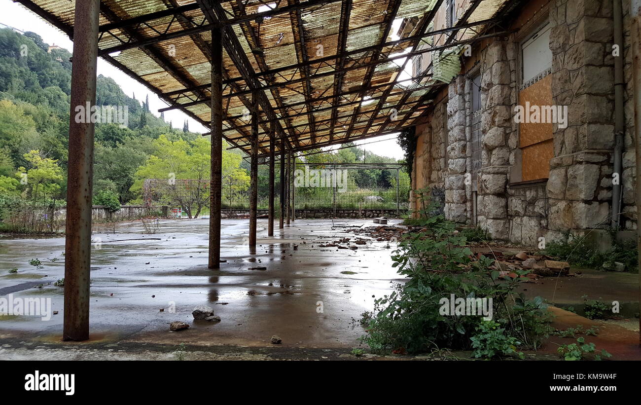 Abandoned hotel terrace with boarded windows in traditional stone wall ...