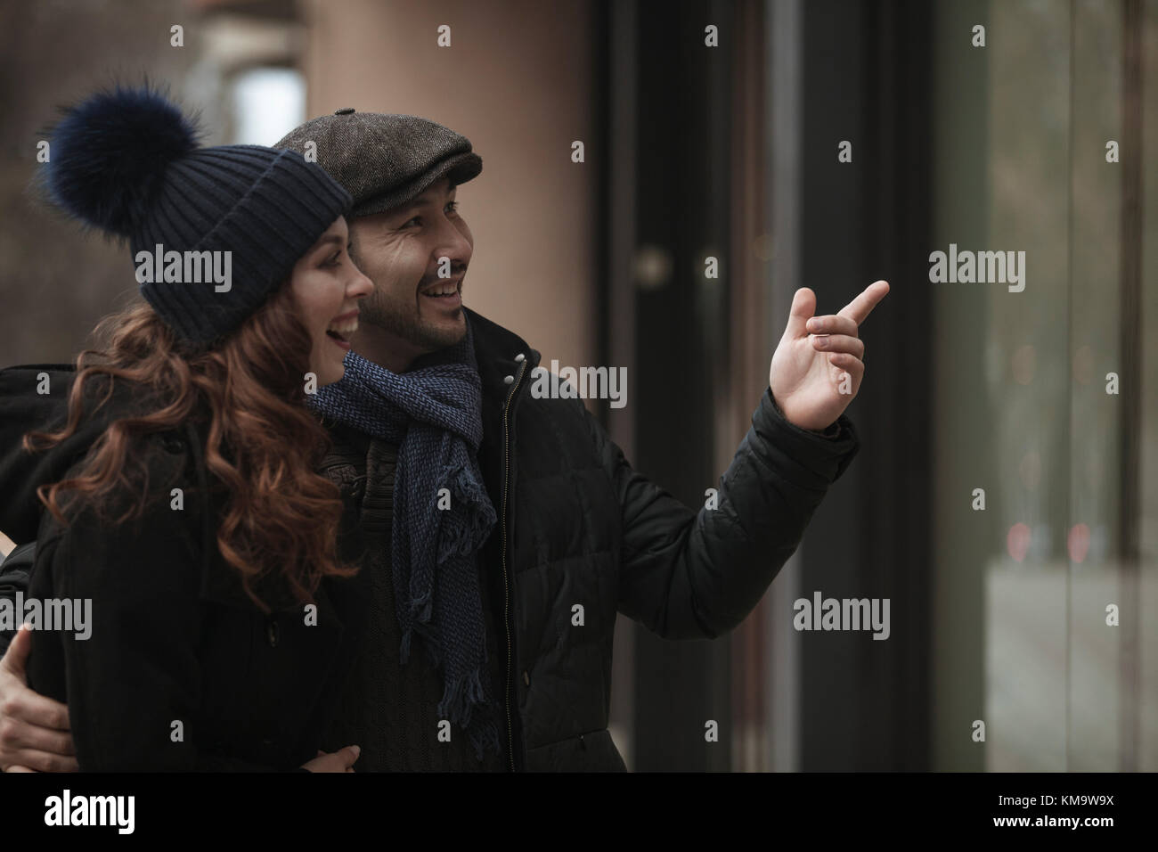 Couple window shopping outdoors in winter city street. Standing in ...