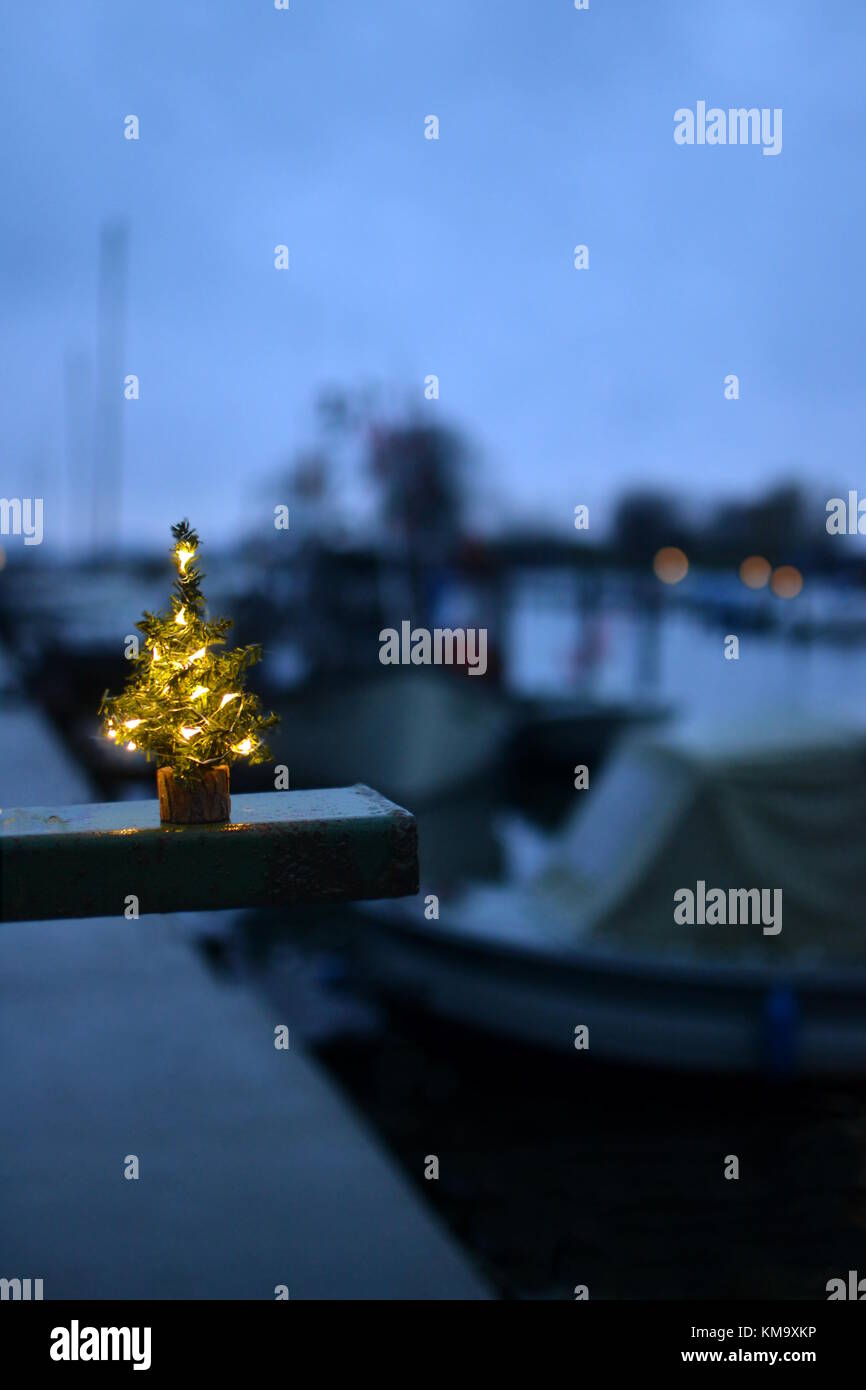 a little christmas tree in a port with ships and boats Stock Photo - Alamy