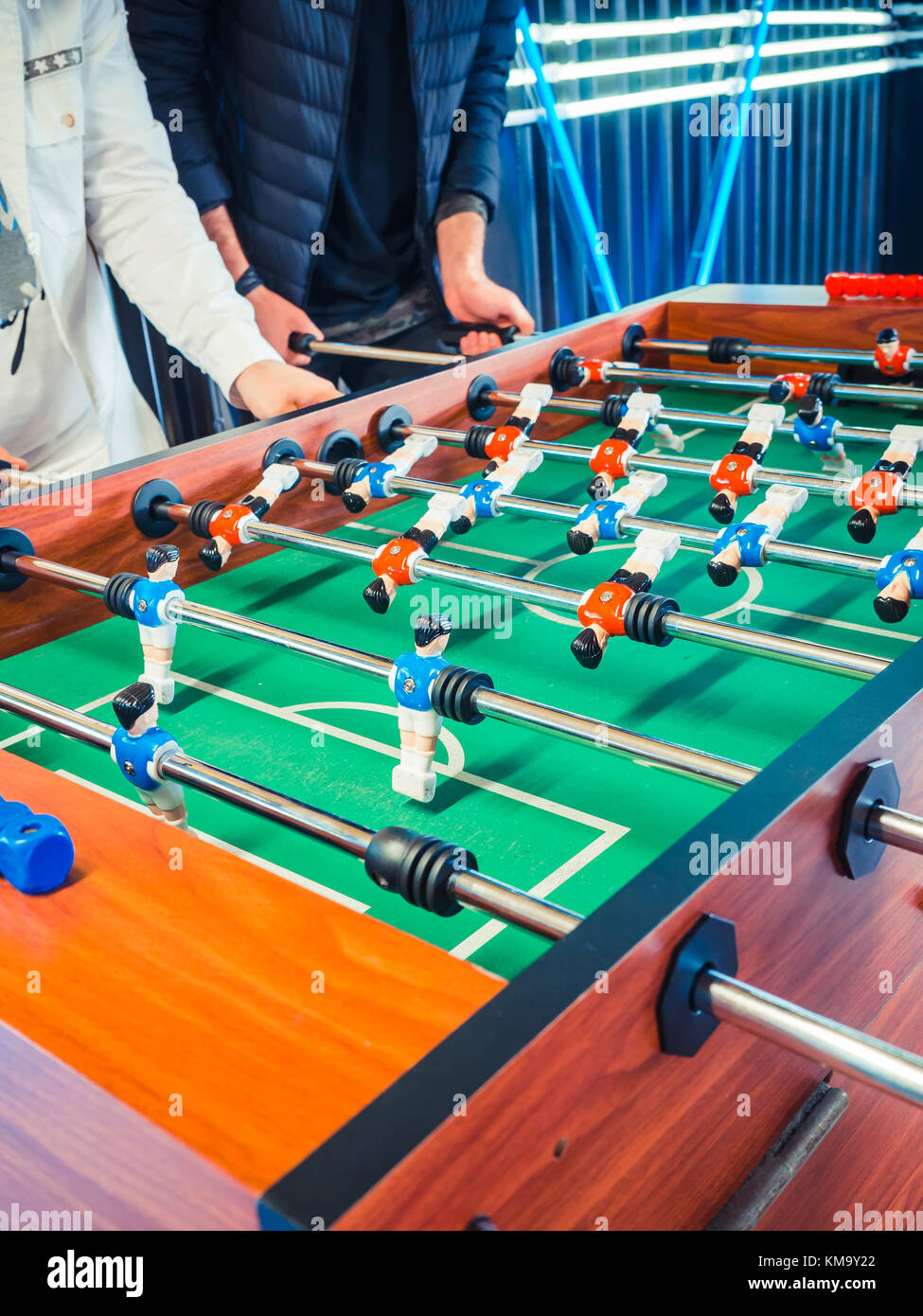 Cropped image of active people playing foosball. table soccer plaers ...