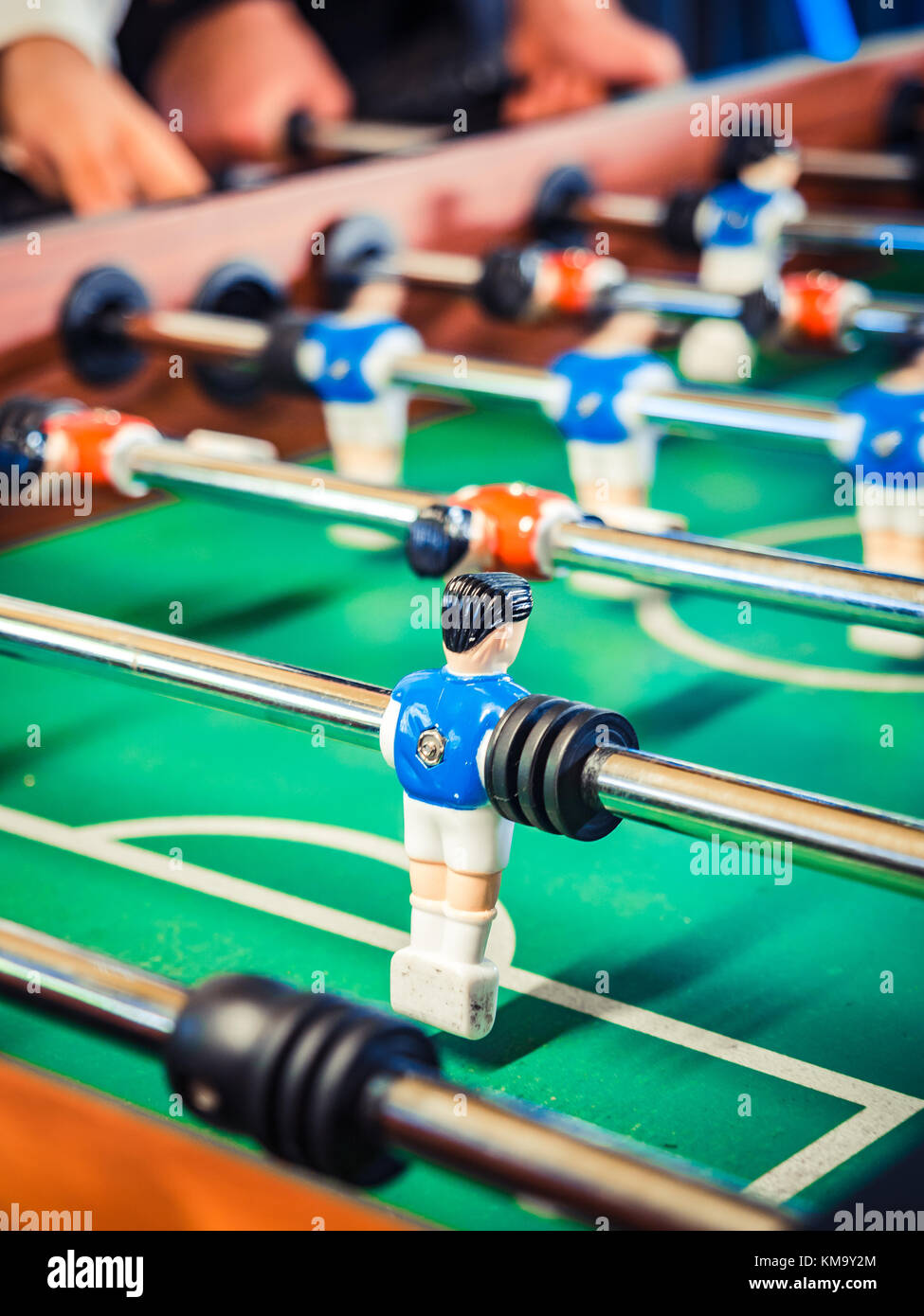 Cropped image of active people playing foosball. table soccer plaers ...