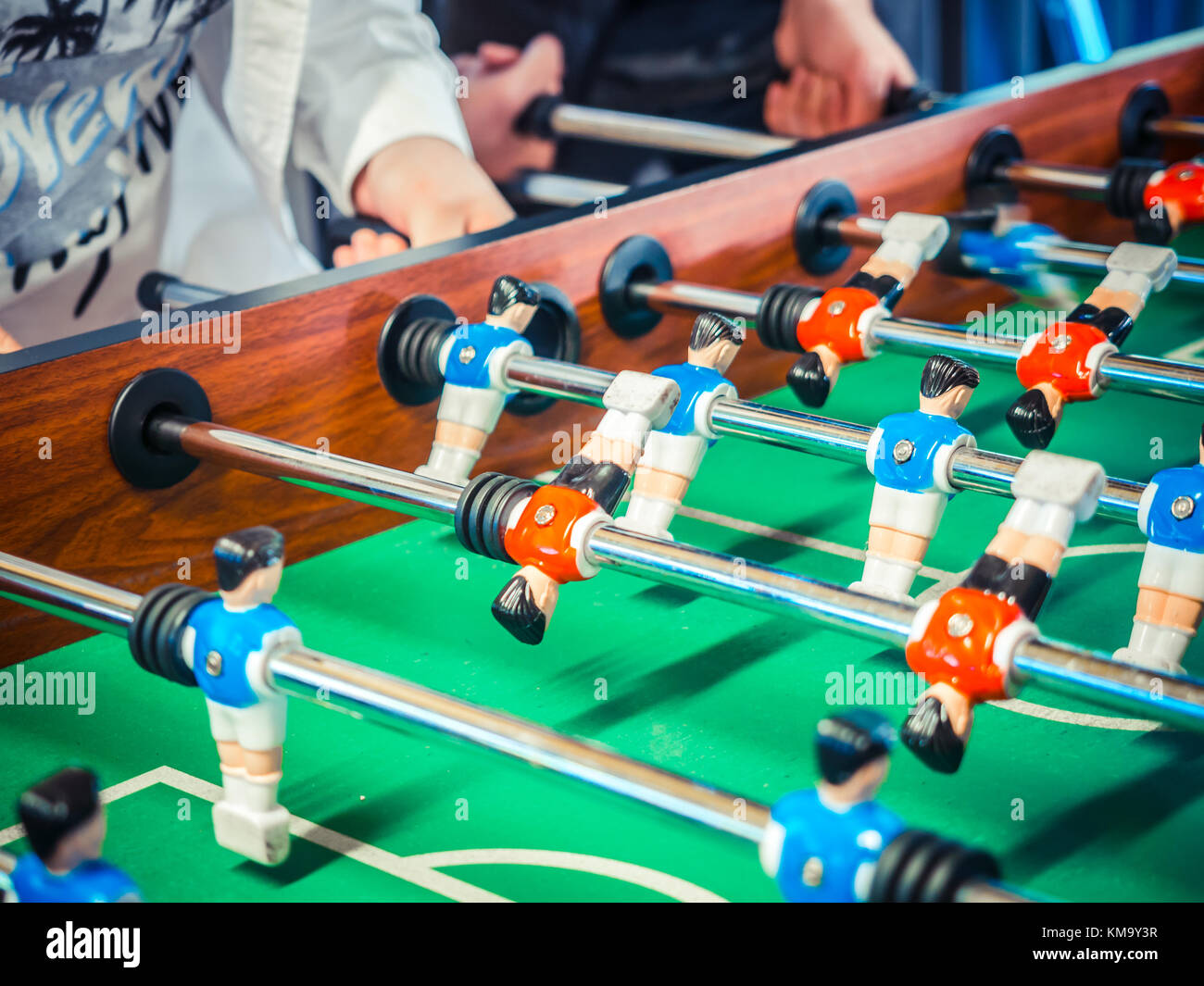 Cropped image of active people playing foosball. table soccer plaers ...