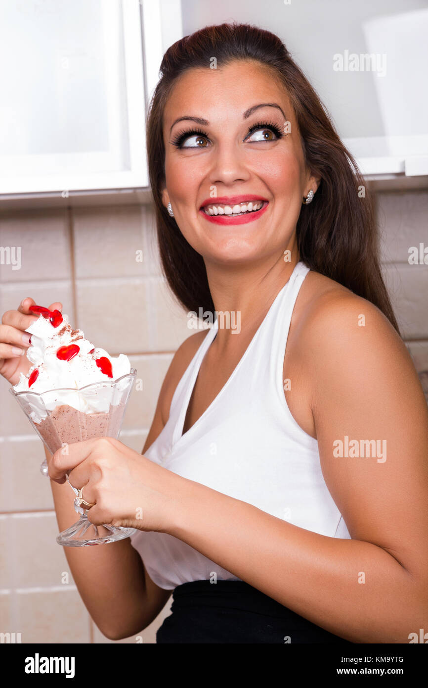 Attractive young satisfied woman eating pudding Stock Photo - Alamy