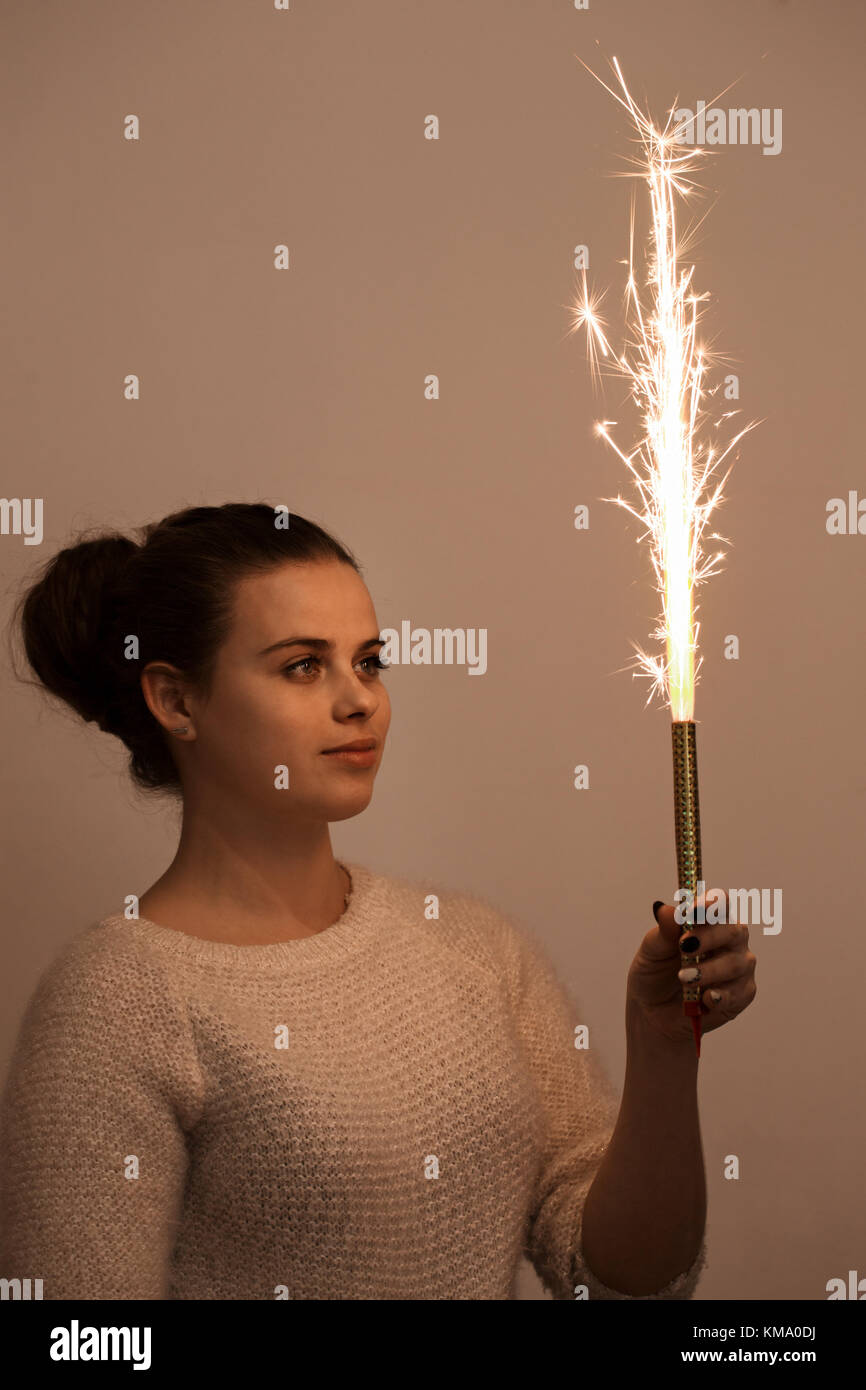 Young beautiful woman holding a burning firework Stock Photo - Alamy