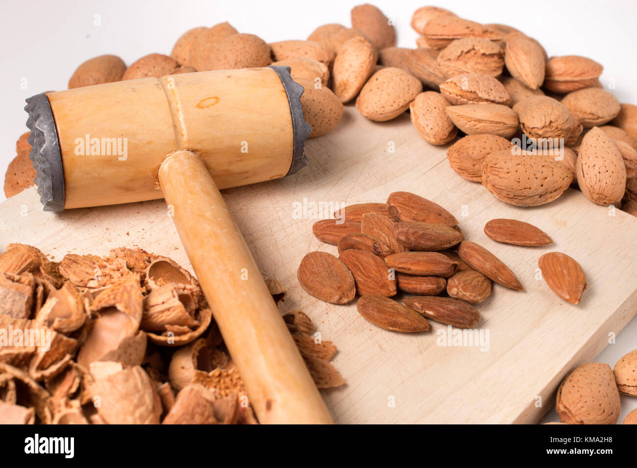 Composition of a kitchen hammer breaking a bunch of sweet almonds Stock ...