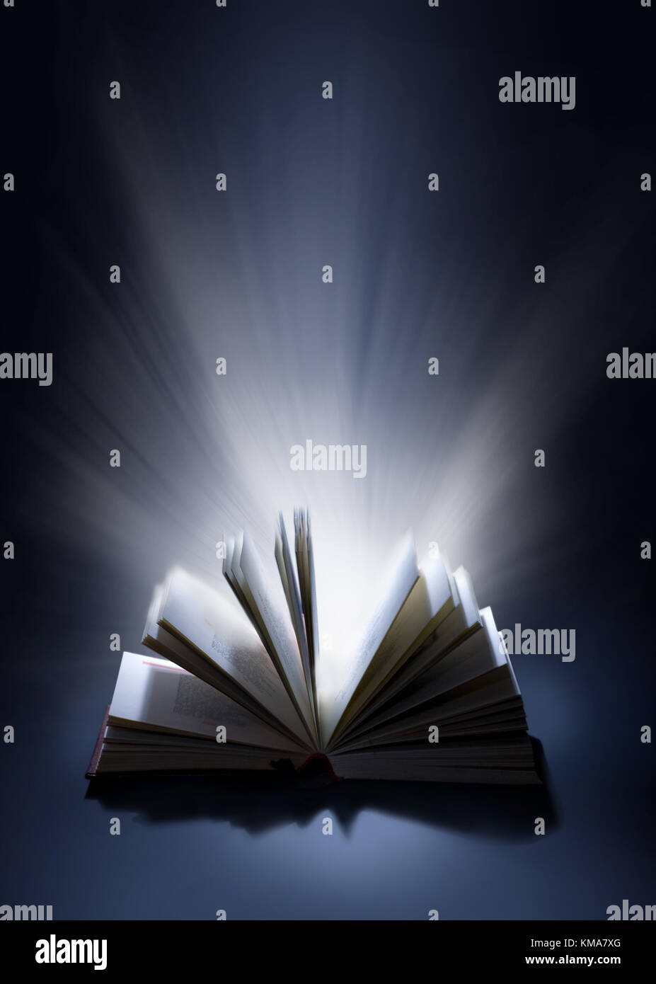 Opened magic book with magic light Stock Photo - Alamy