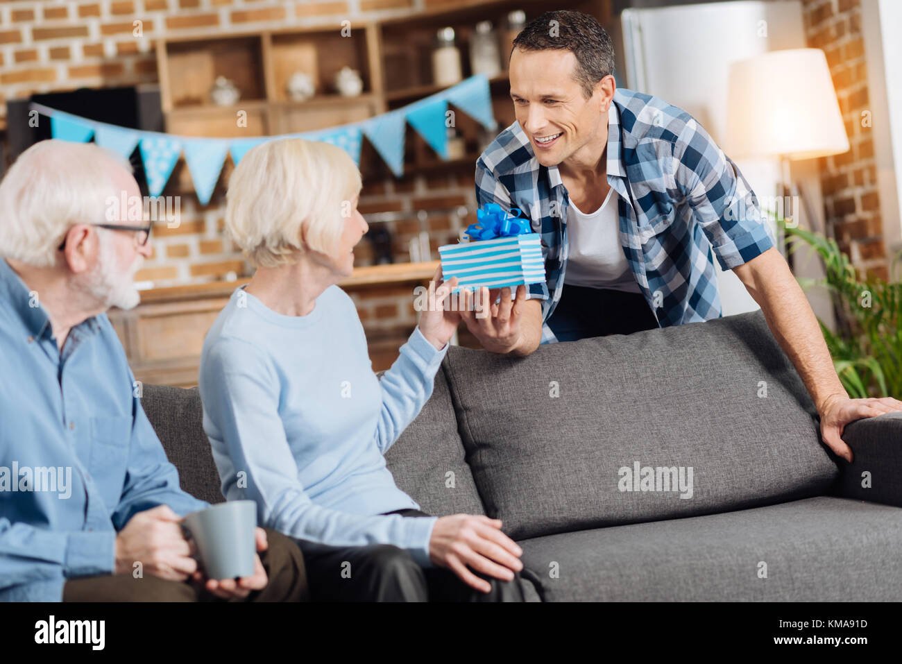 Charming man giving a present to his senior mother Stock Photo - Alamy