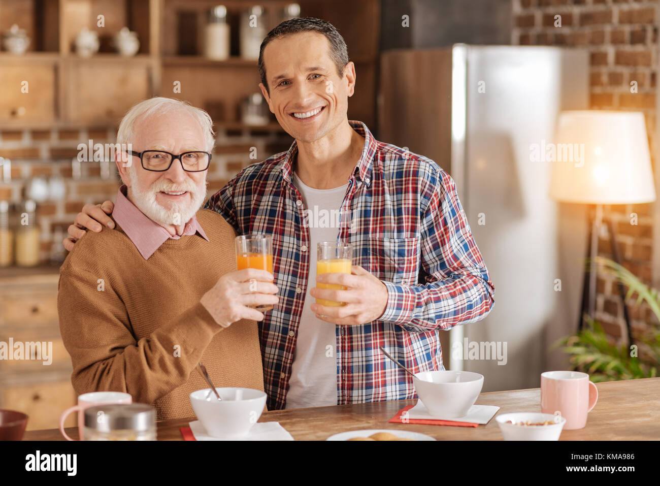Cheerful father and son posing with glasses of juice Stock Photo - Alamy