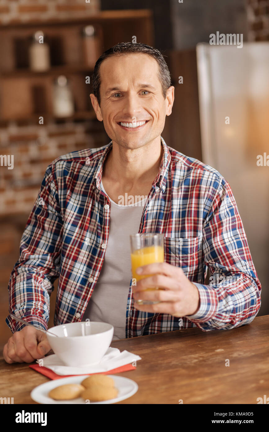Cheerful young man posing while enjoying his breakfast Stock Photo - Alamy