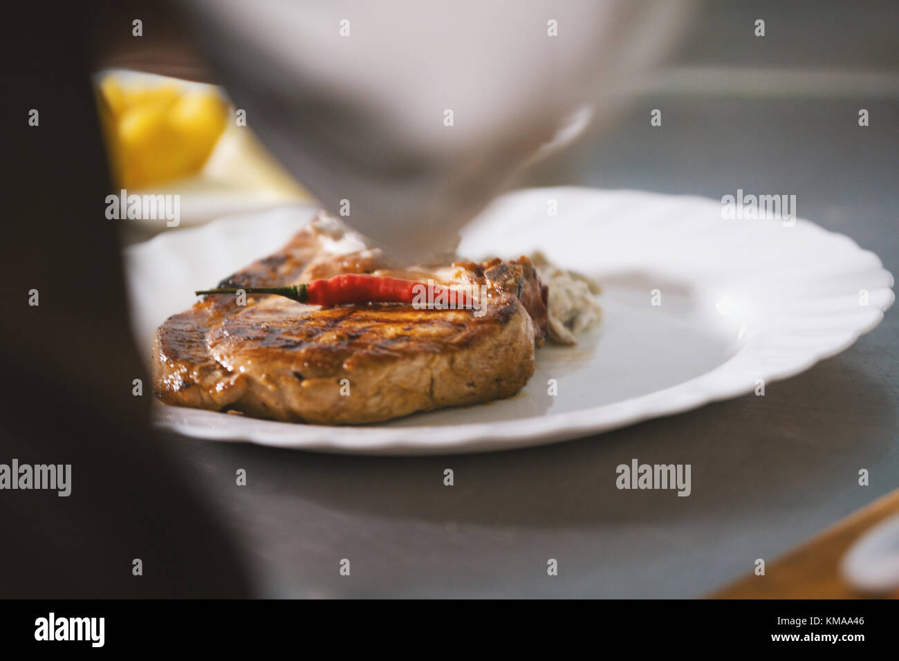 Chef serves meat on the plate Stock Photo - Alamy