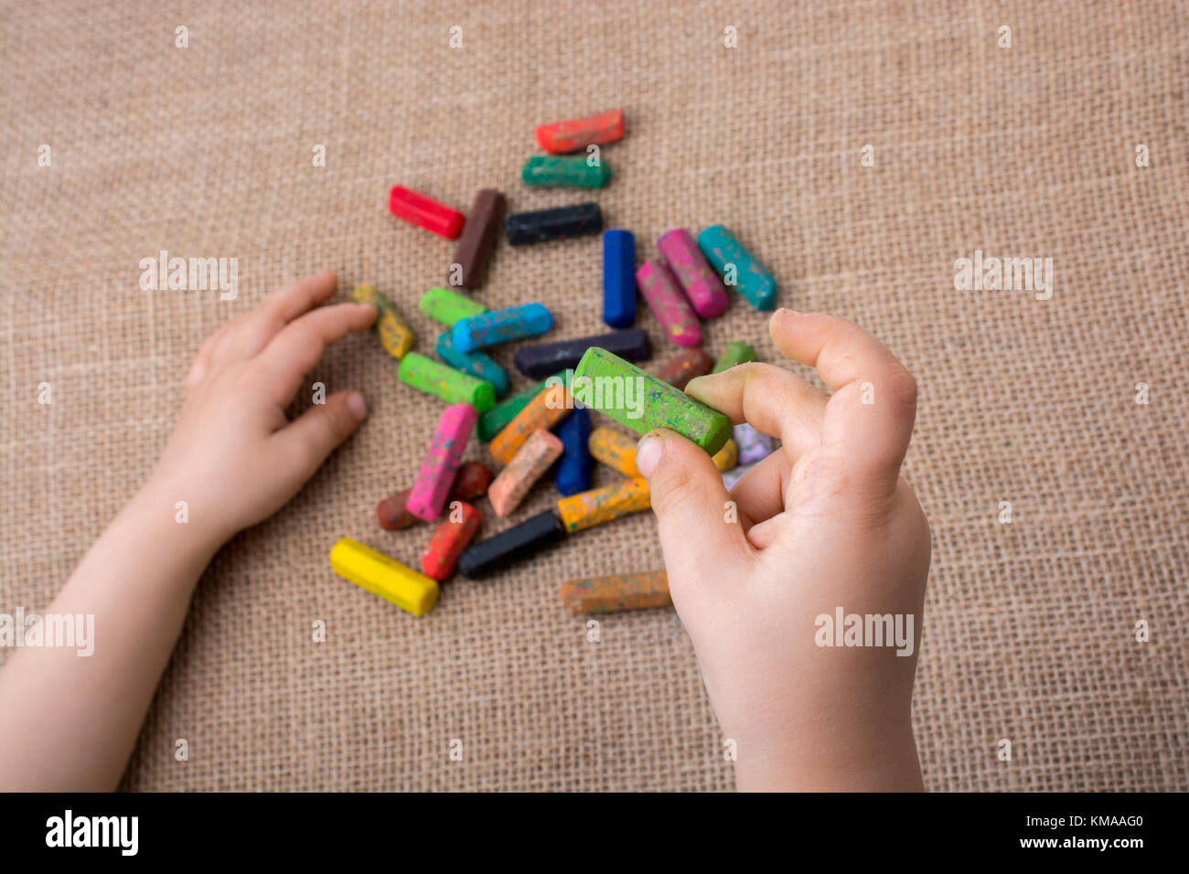 Used color crayons and a toddlers hand holding one Stock Photo - Alamy