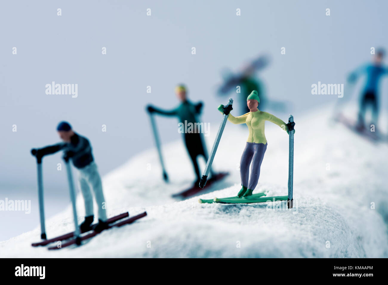 some different miniature skiers in a snowy landscape on winter time ...