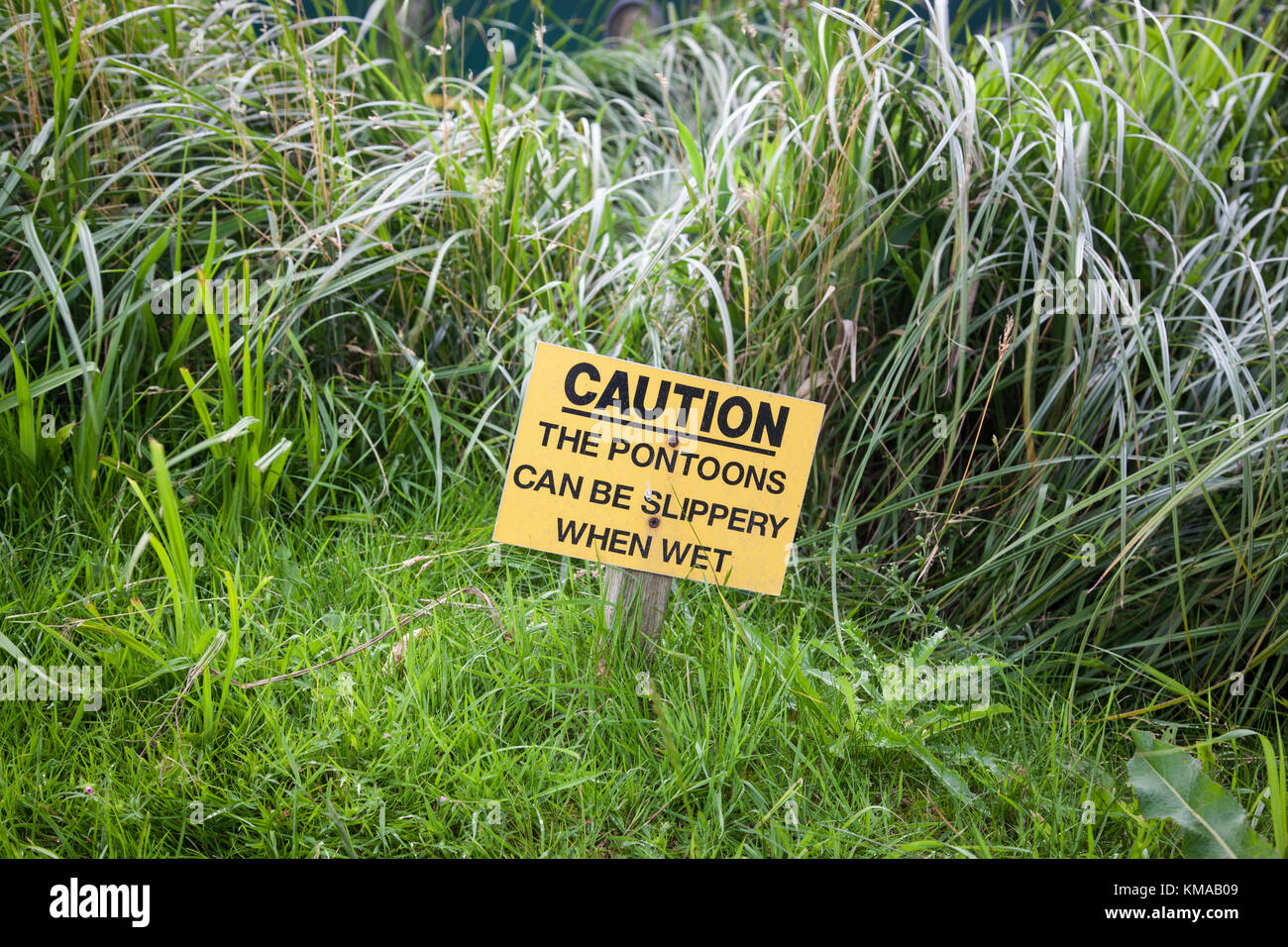 Black on yellow sign at a marina warning that pontoons can be slippery ...