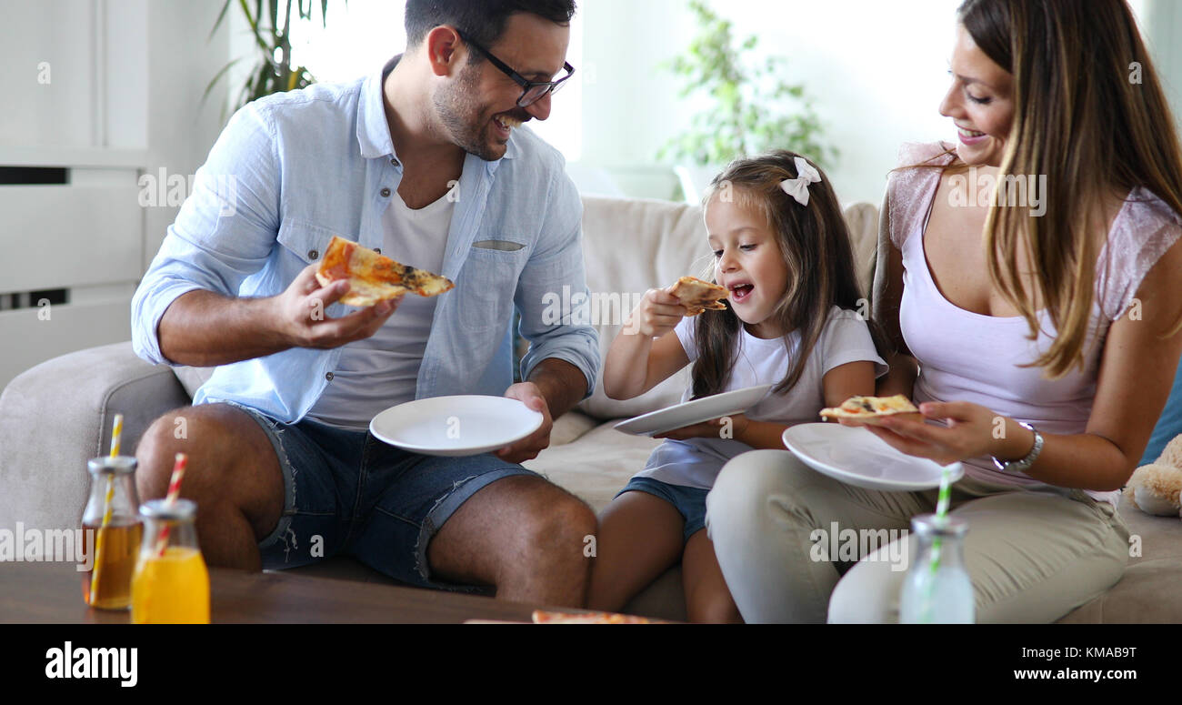 Happy family sharing pizza together at home Stock Photo - Alamy