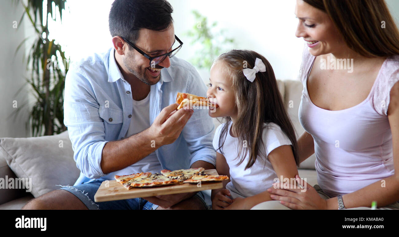 Happy family sharing pizza together at home Stock Photo - Alamy
