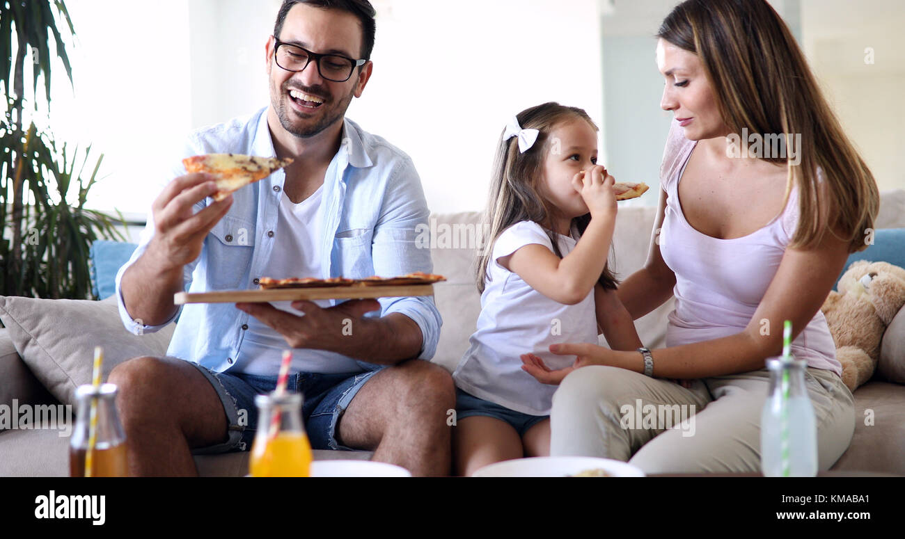 Happy family sharing pizza together at home Stock Photo - Alamy