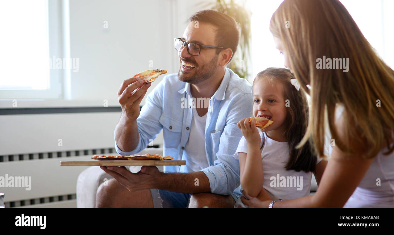 Happy family sharing pizza together at home Stock Photo - Alamy