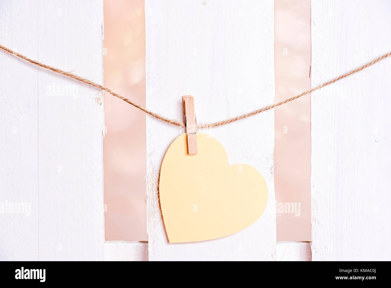 Paper note, heart-shaped, tied to a linen string with a wooden clip, on ...