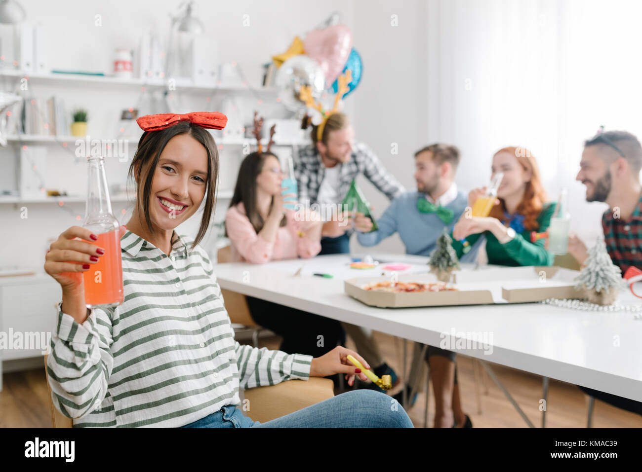 Sweet employee toasting at office party with colleagues in background ...