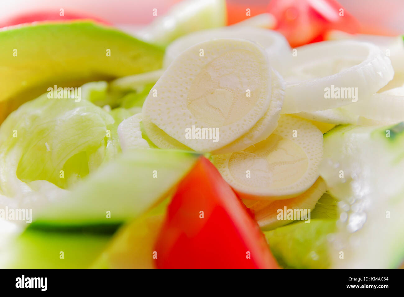 Close up of fresh salad with vegetables, tomato, onion, palmito ...