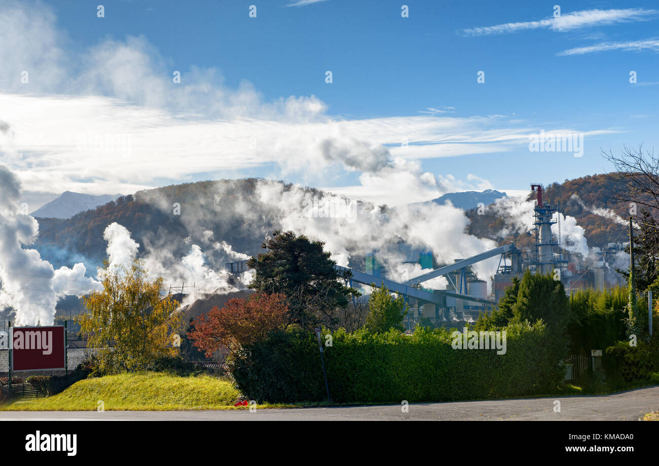 factory with smoke, the mountains on background Stock Photo - Alamy
