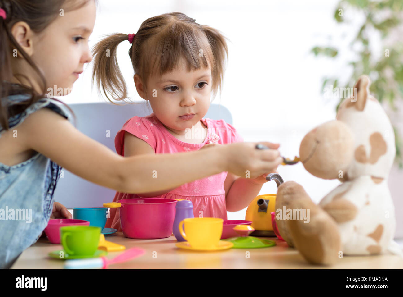 Close-up portrait of cute adorable little kids feeding caw plush toy ...