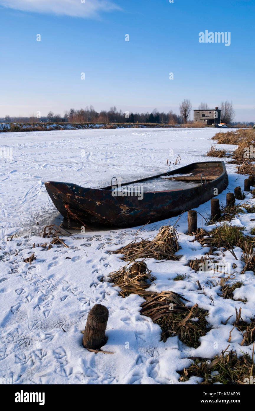 Rowing boat in the ice of the frozen river Giessen near Hoornaar in the ...