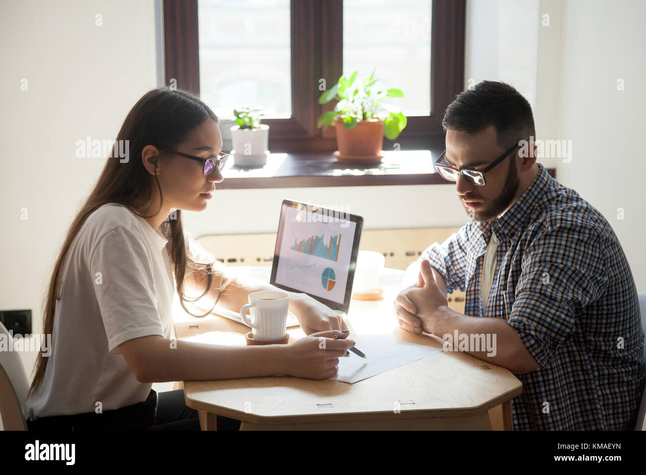 Two millennial coworkers discussing working problems on business ...