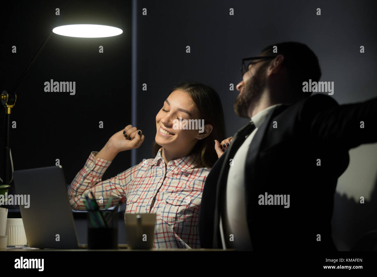 Young positive managers resting at office after well done work. Smiling ...
