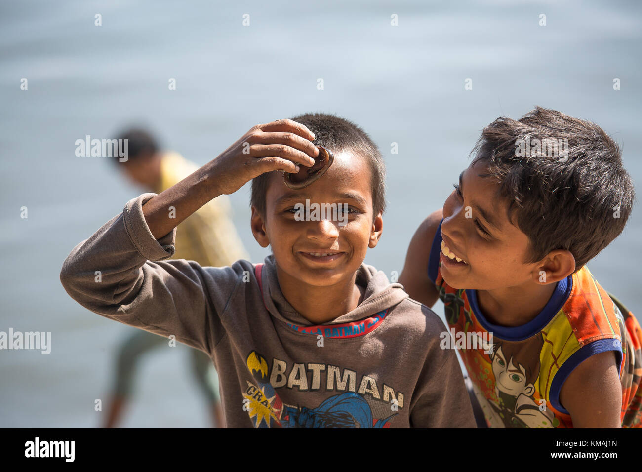 Two kids are playing Baim(Spiny eel) baby fish at a river side ...