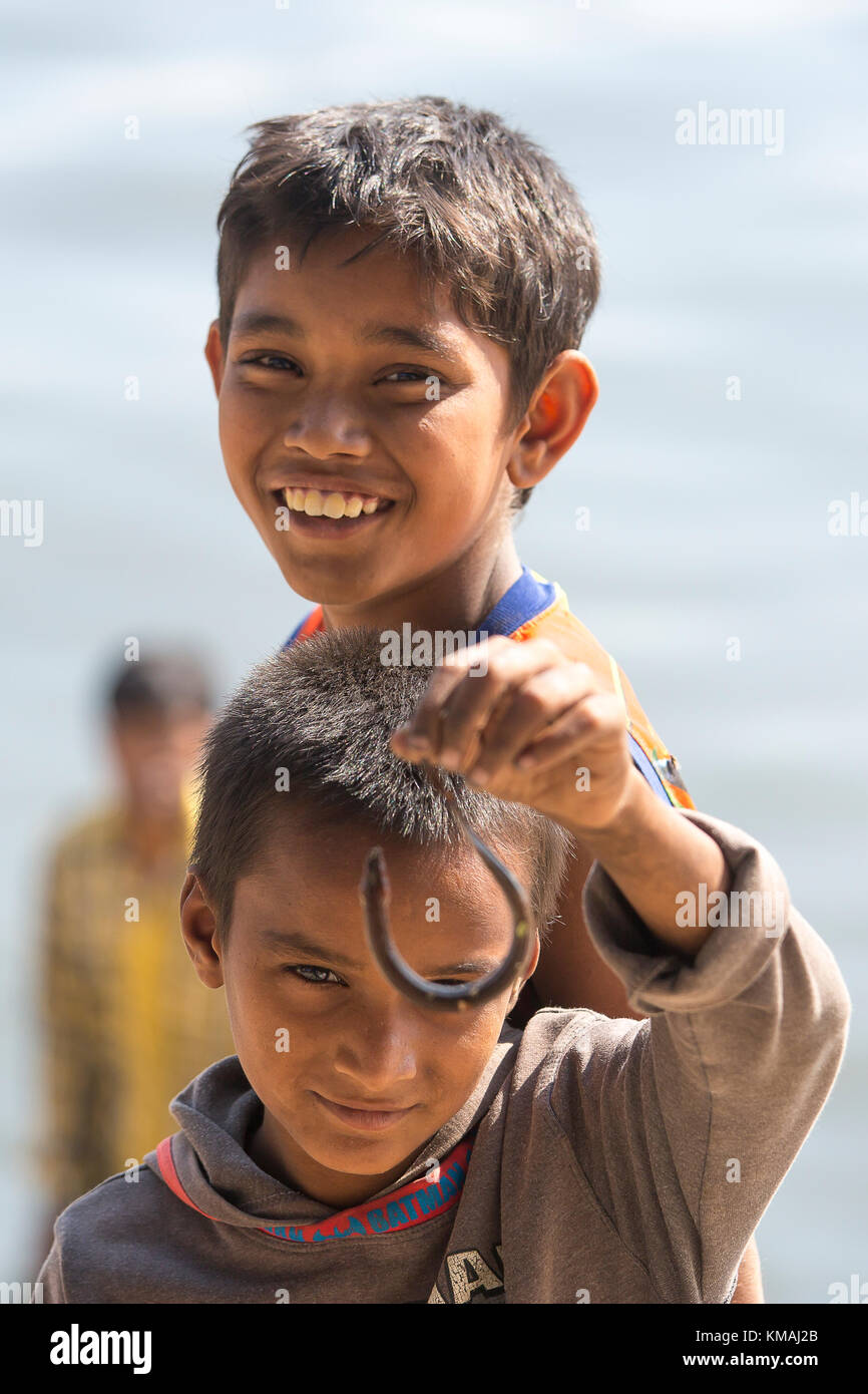 Two kids are playing Baim(Spiny eel) baby fish at a river side ...