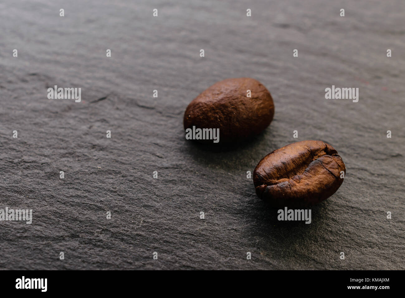 Two coffee beans on a rough surface, close up, side view Stock Photo ...