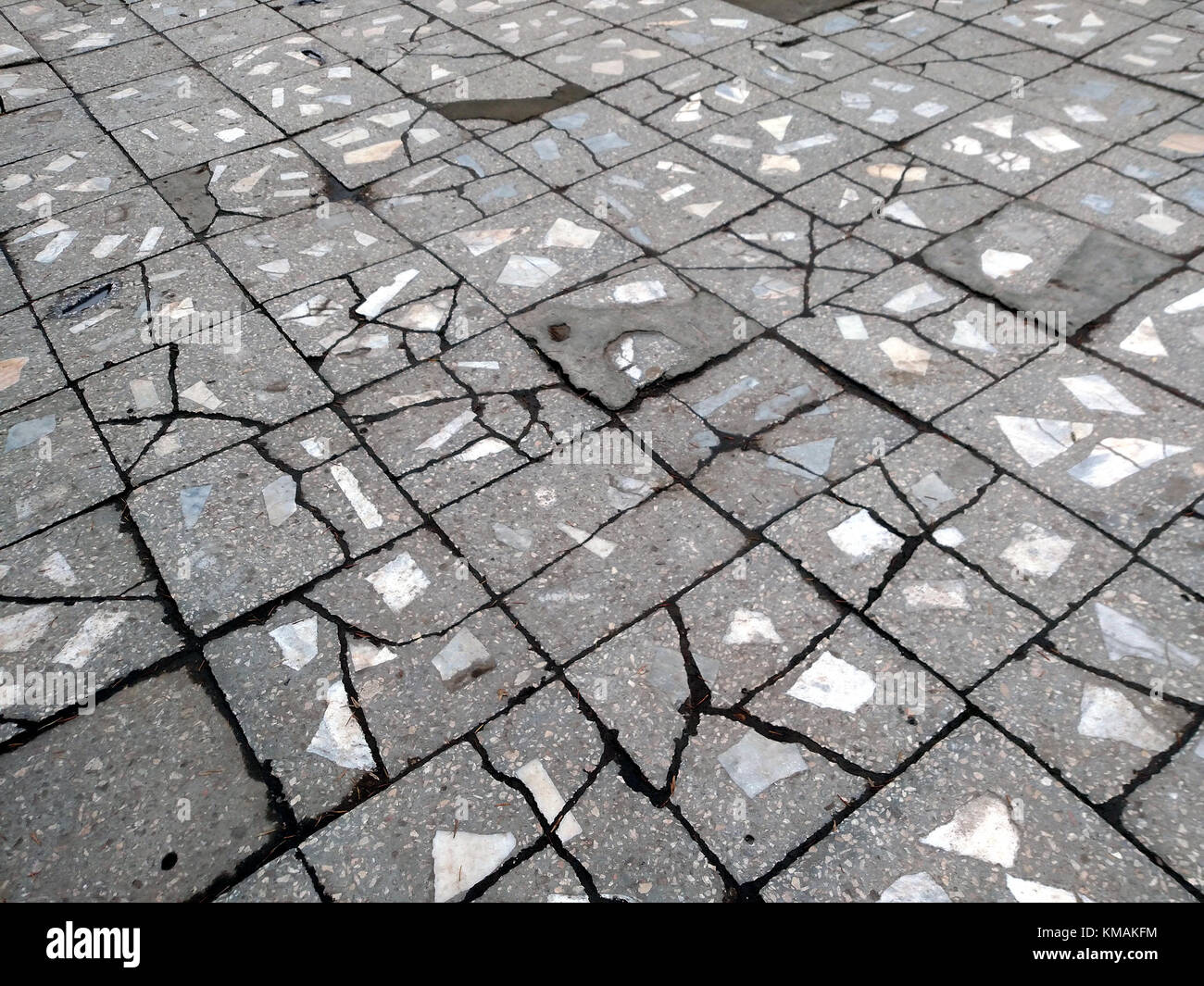 Pavement made from old cracked concrete tiles Stock Photo - Alamy