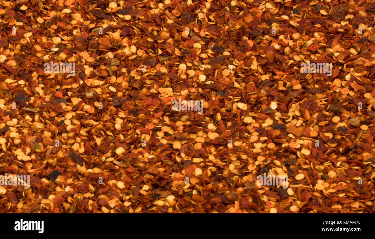 Dried chili pieces red pepper crushes macro background Stock Photo - Alamy