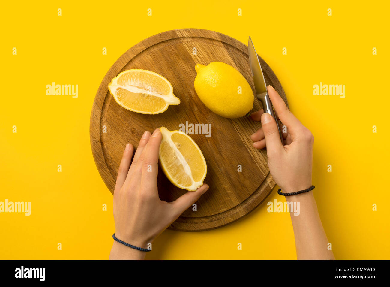 Woman cutting lemon on wooden hi-res stock photography and images - Alamy