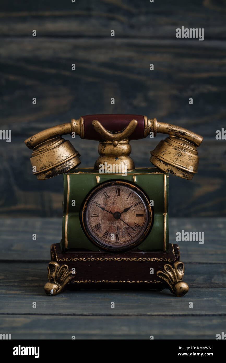 Desk clock with antique telephone design on blue background Stock Photo ...