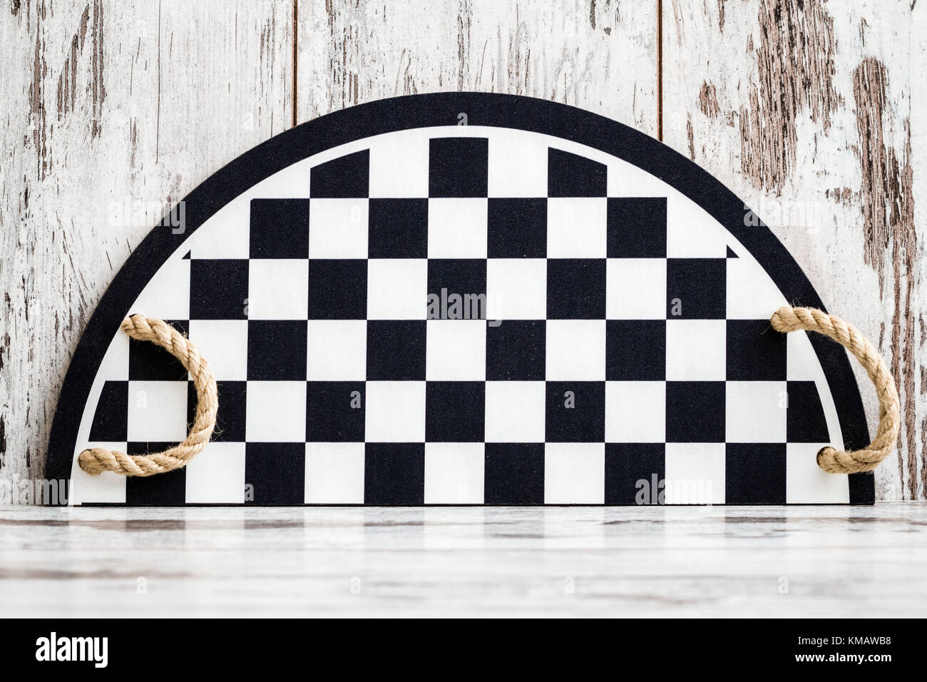 Tray with black and white checkers pattern and handles on white wooden ...