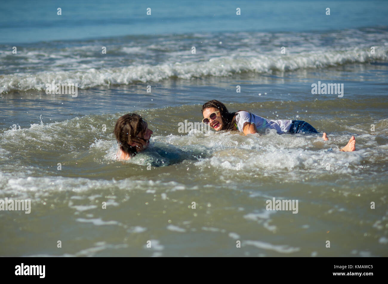 Young couple bathing in the sea. Guy and girl are merrily floundering ...