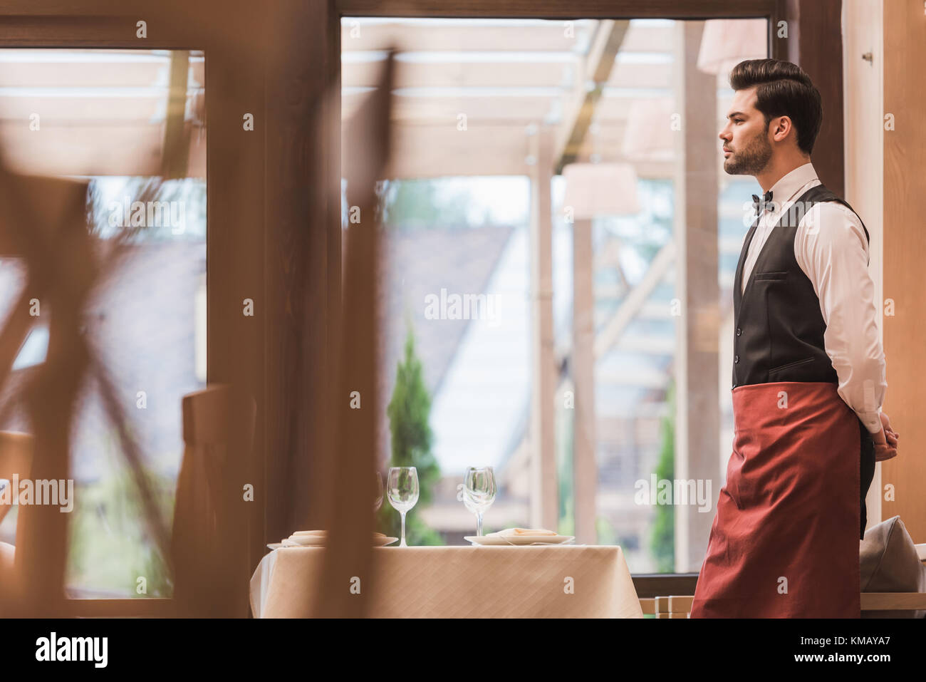 waiter standing near empty table Stock Photo - Alamy