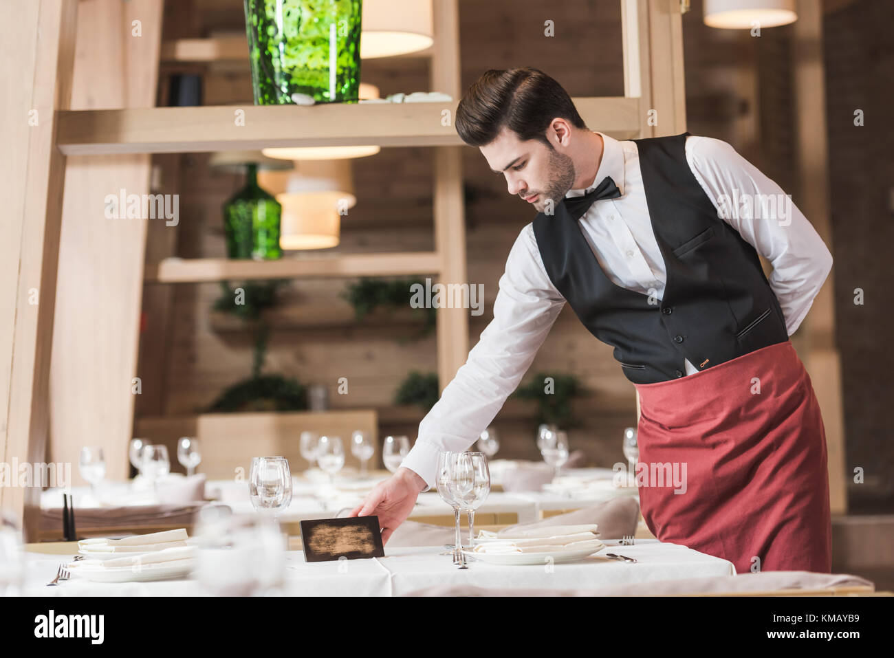 Waiter putting reserved sign Stock Photo - Alamy